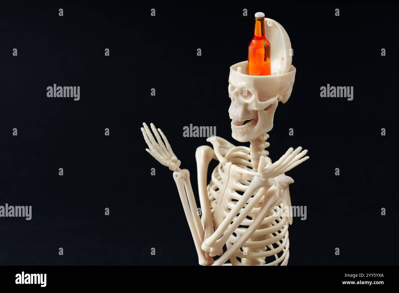 Skeleton figurine with alcohol bottle resting in its open head ...