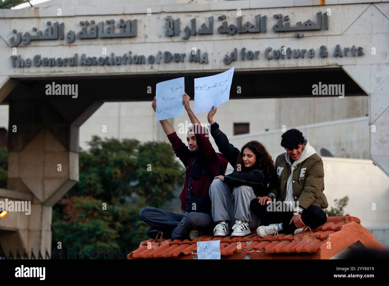 Syrian activists hold placards with Arabic that read: "The art is voice ...