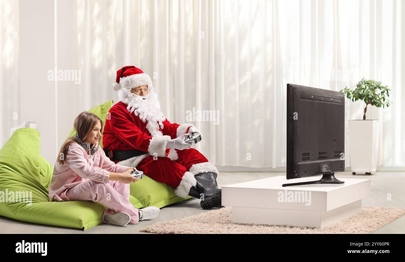 Santa claus playing video games with a teenage girl, gaming concept ...