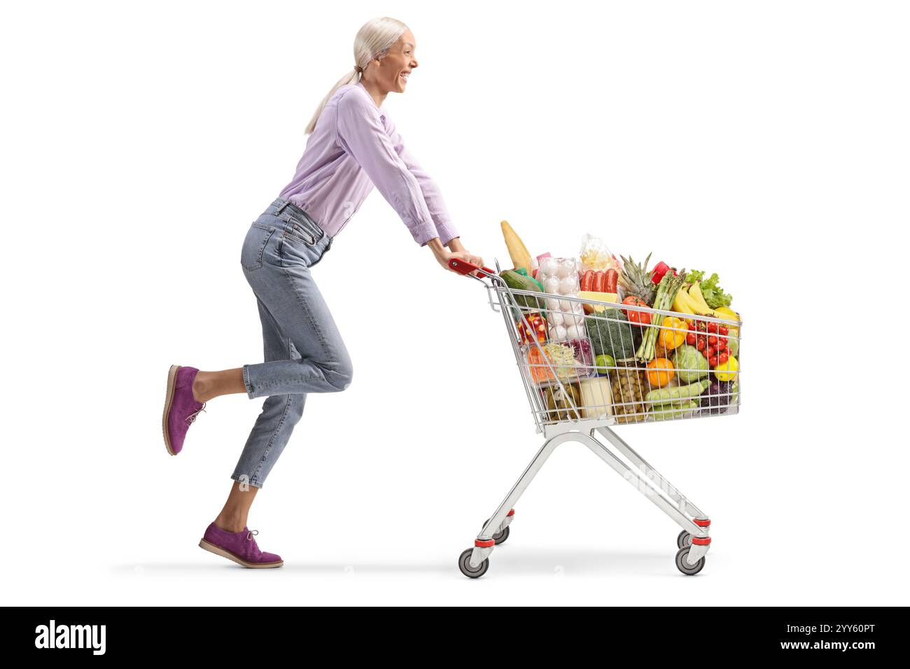 Woman running and pushing a shopping cart with groceries isolated on ...