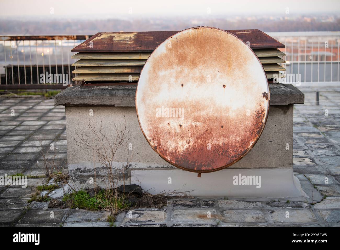 Old rusty satelite antenna dish on roof of the building hangs on the ...