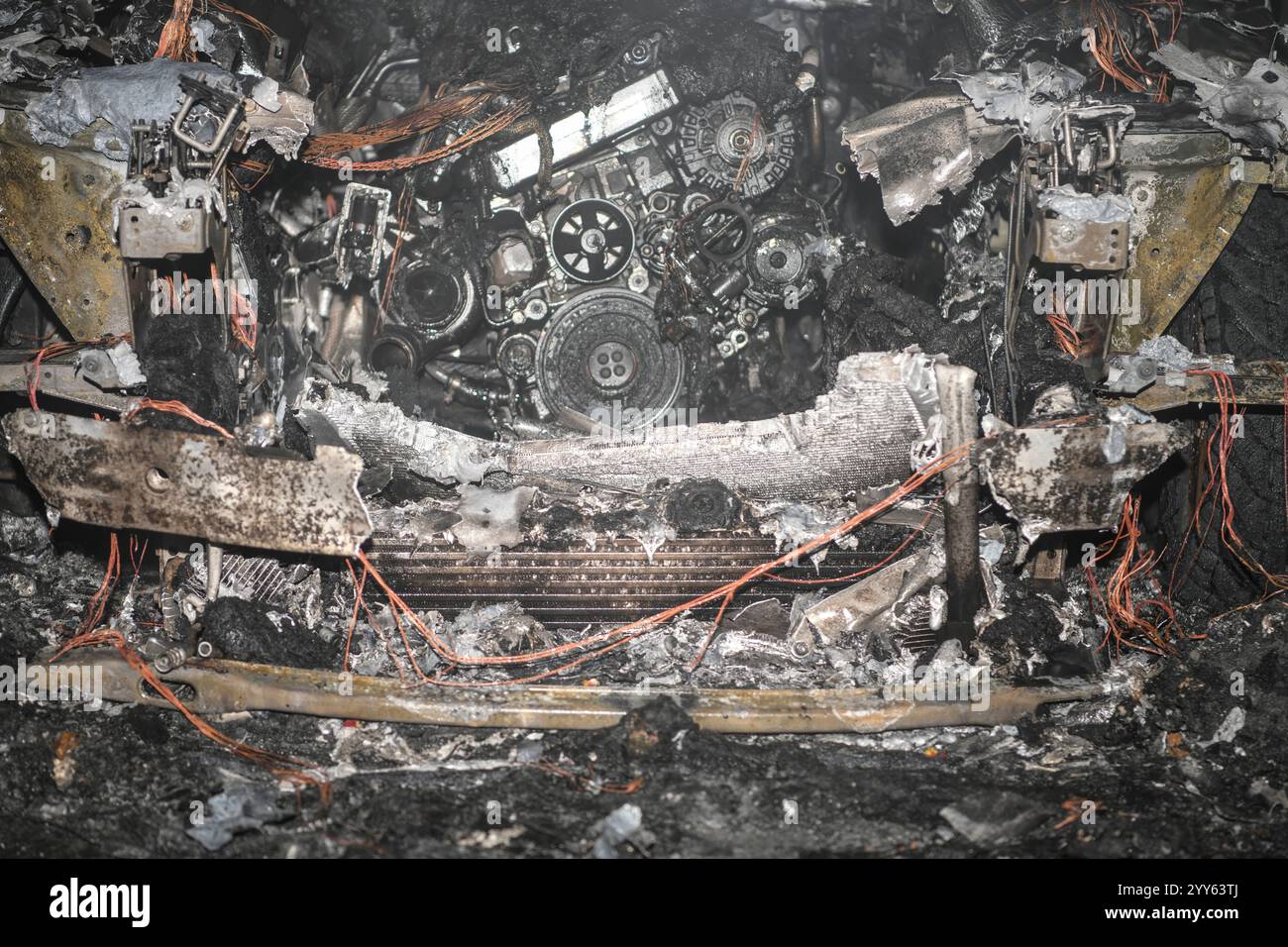 Car exploded and destroyed on fuel pump in accident. Closeup view of destroyed car motor and ...