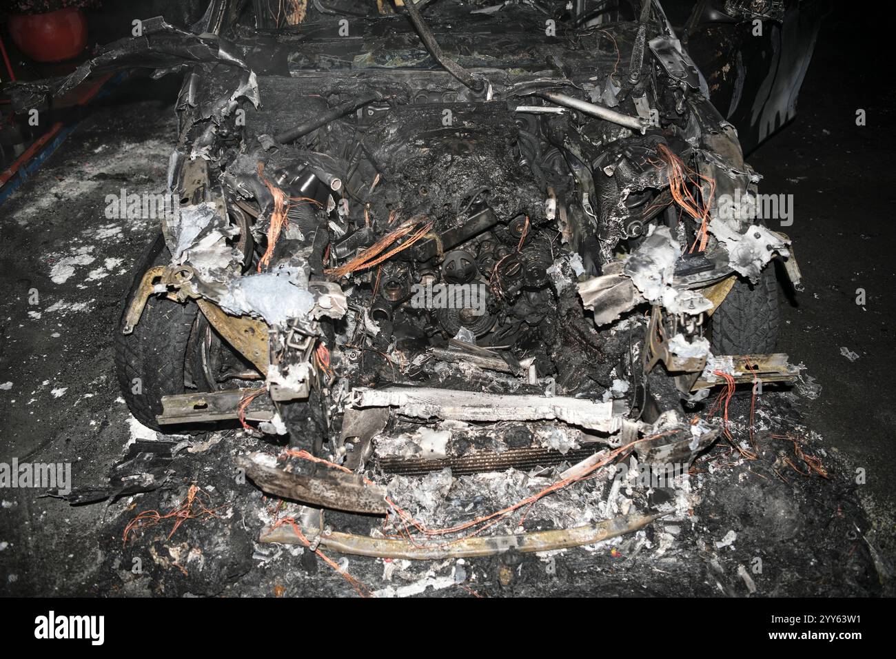 Car exploded and destroyed on fuel pump in accident. Closeup view of destroyed car motor and ...