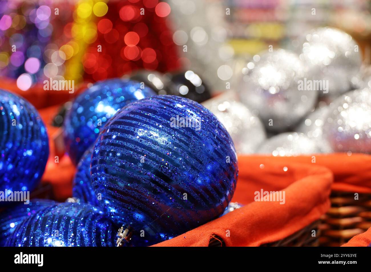 Christmas toys, blue balls in red basket on blurred festive lights ...