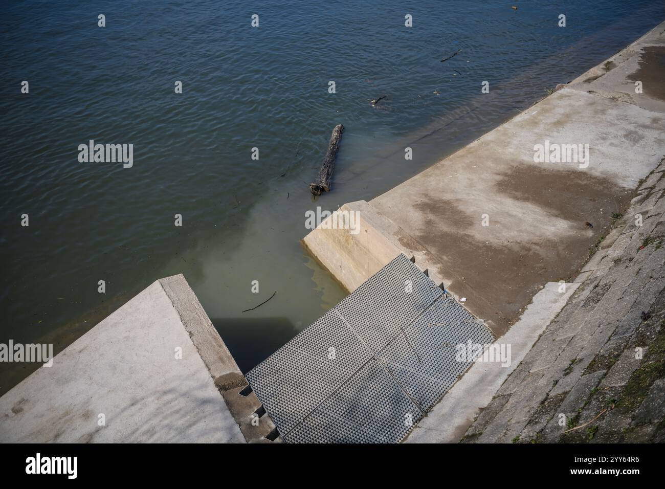 Dirty orange water from sewage pipeline mixes with river water in the ...