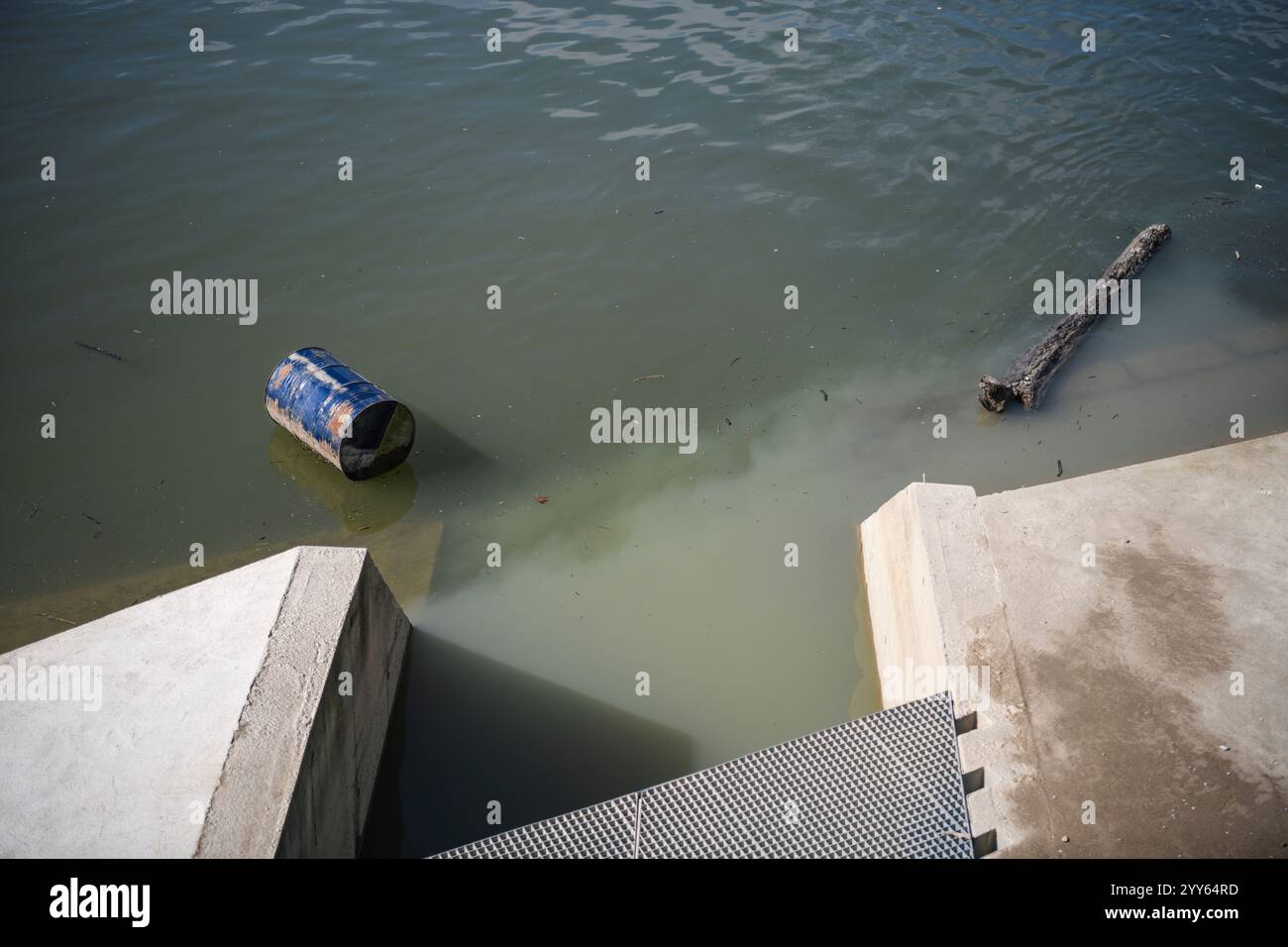 Dirty orange water from sewage pipeline mixes with river water in the ...