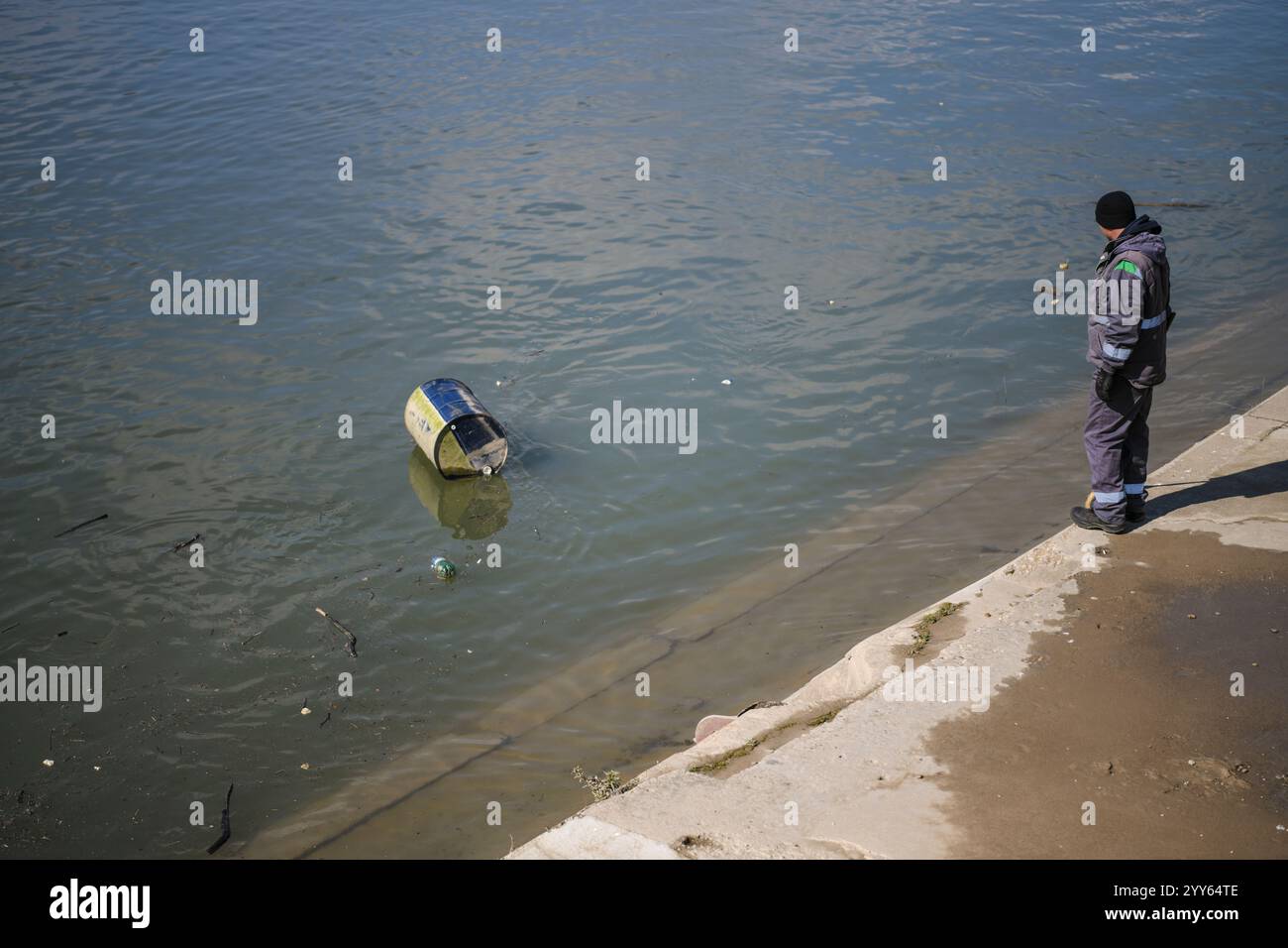 Dirty orange water from sewage pipeline mixes with river water in the ...