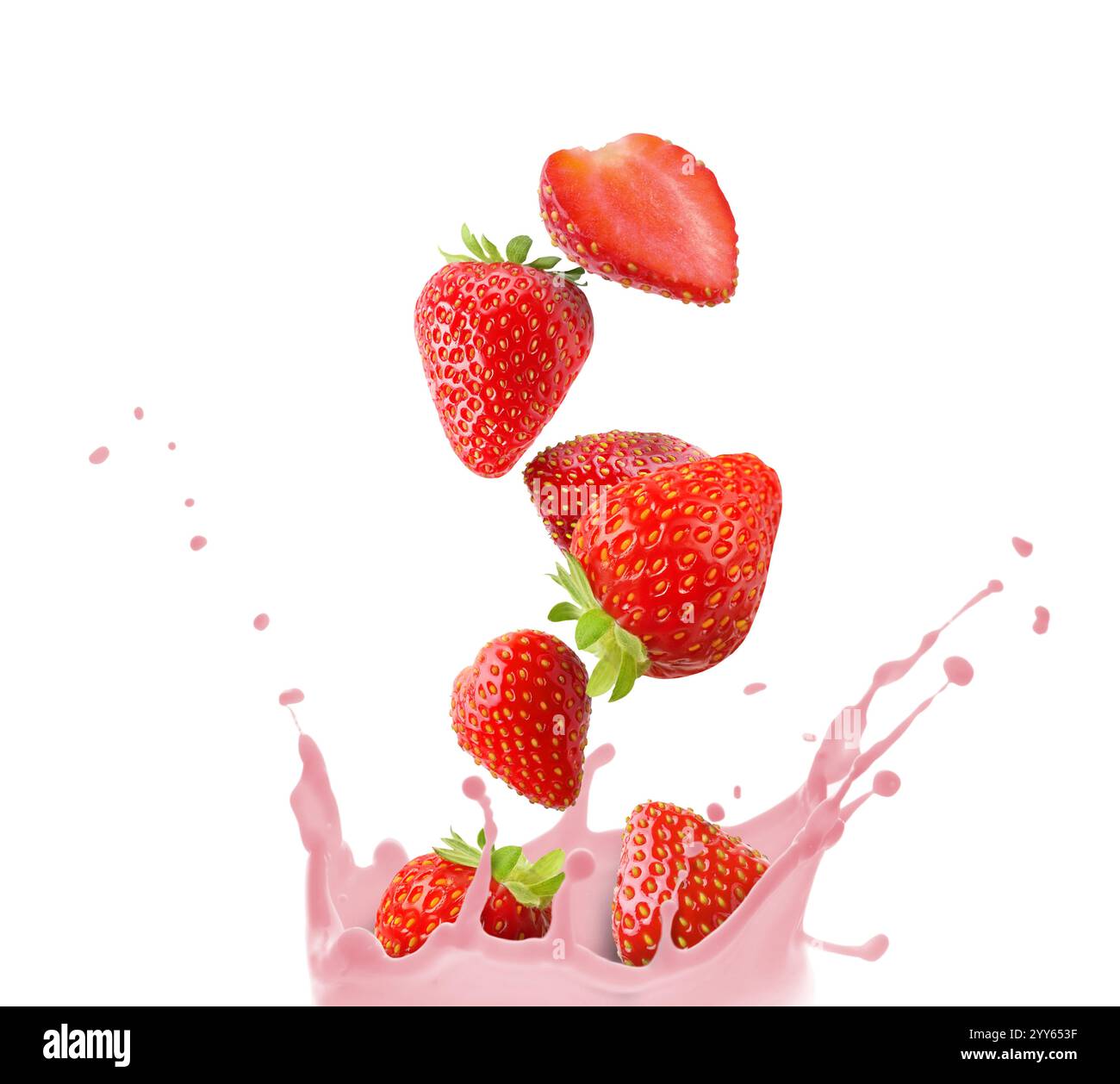Strawberries falling into tasty milkshake on white background Stock ...