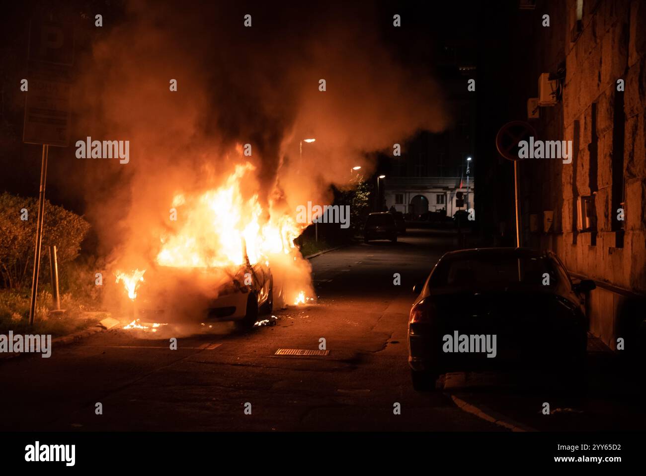 Burning police car in the center of city near church during riots ...