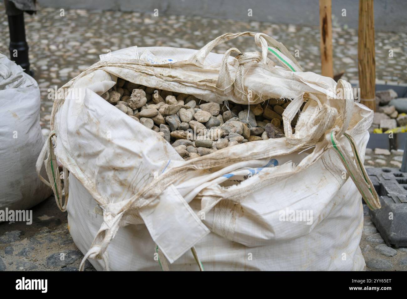 White bags of crushed stones are in a row, building material in the ...