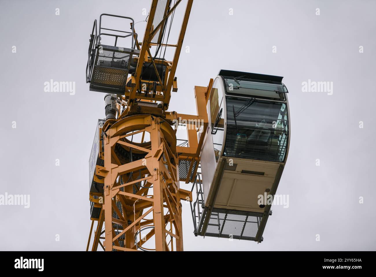 Closeup view of the control cabin of a yellow construction tower crane ...