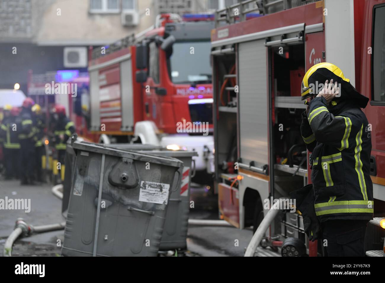 A firefighter puts on a protective suit and helmet before he starts of ...