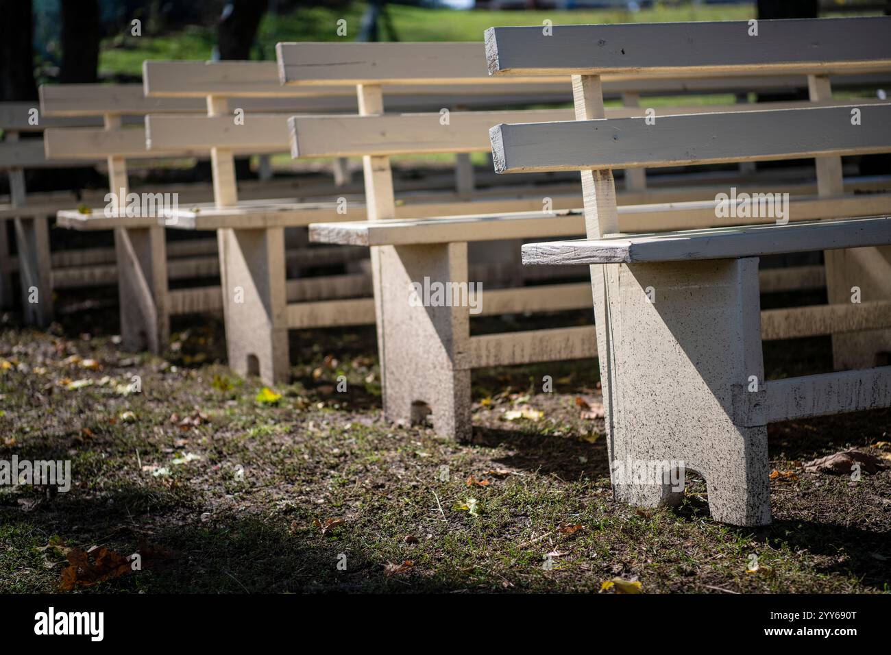 A row of white long wooden benches for invitees. Beautiful location for ...