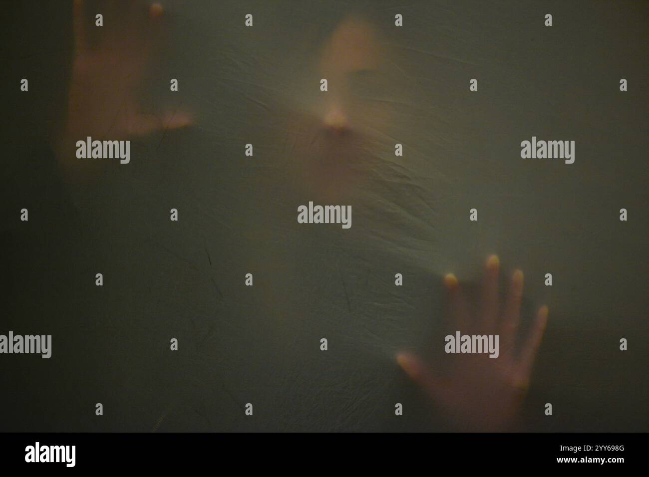 Head and handprint of woman as she suffocates behind fabric, raised ...