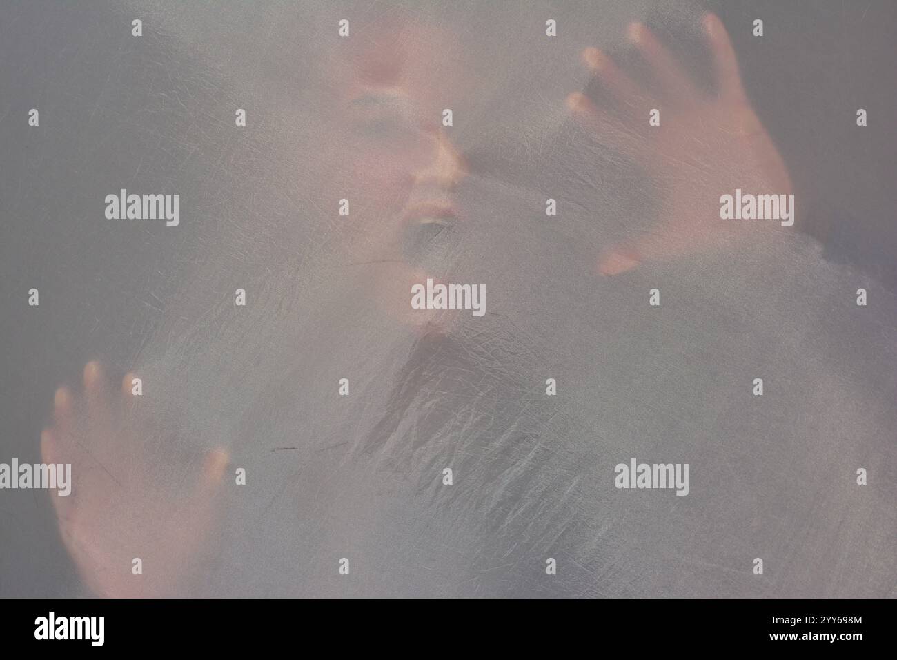Head and handprint of woman as she suffocates behind fabric, raised ...