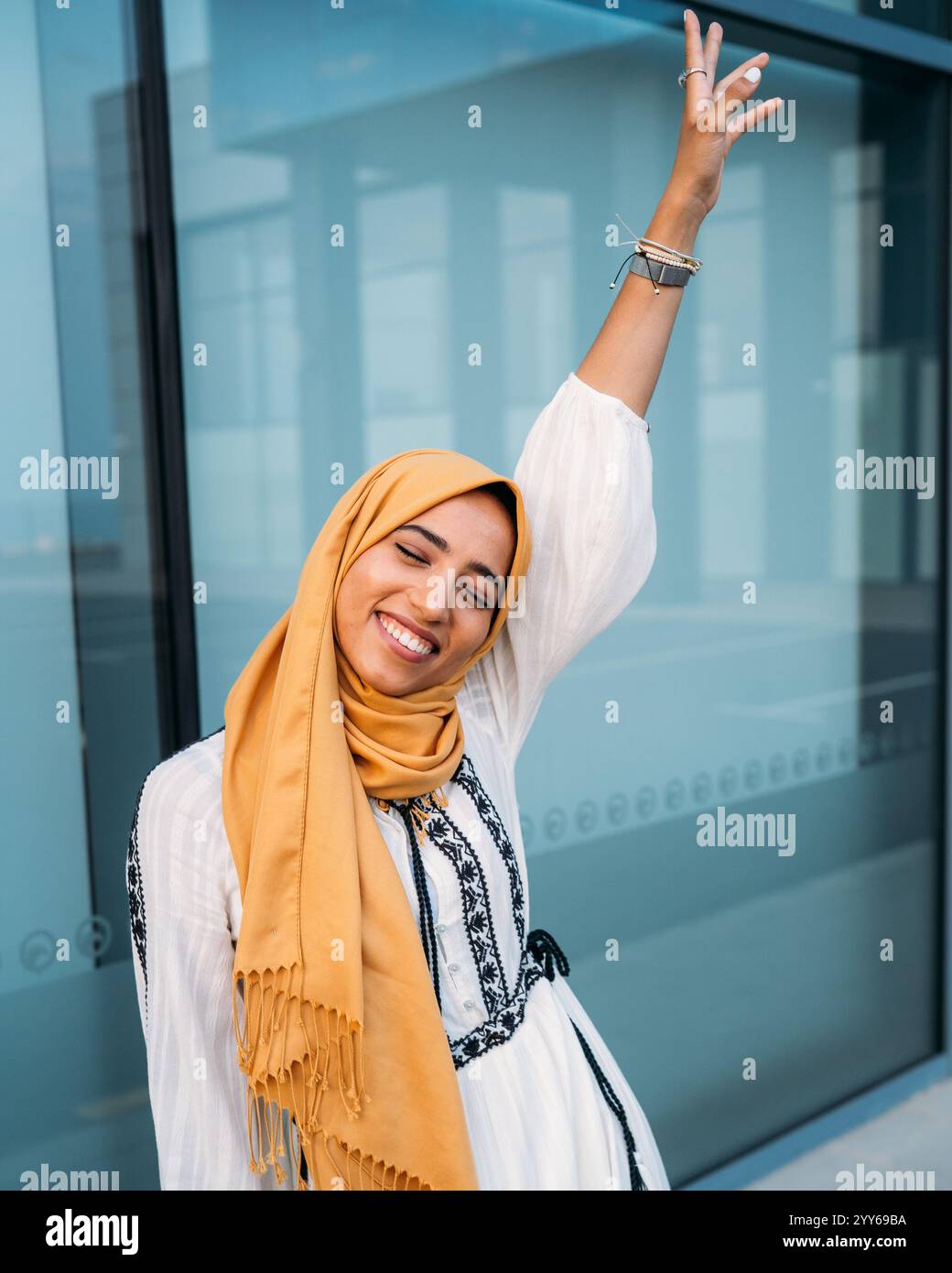 Happy muslim woman wearing hijab dancing in the street Stock Photo - Alamy