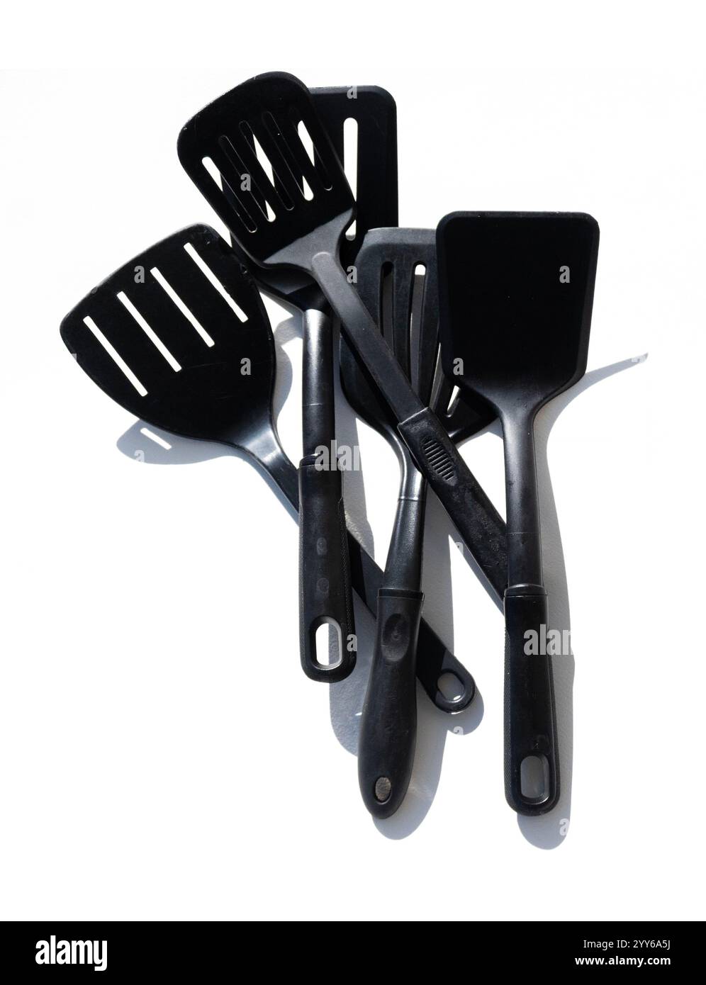A collection of black plastic spatulas on white background, and ...