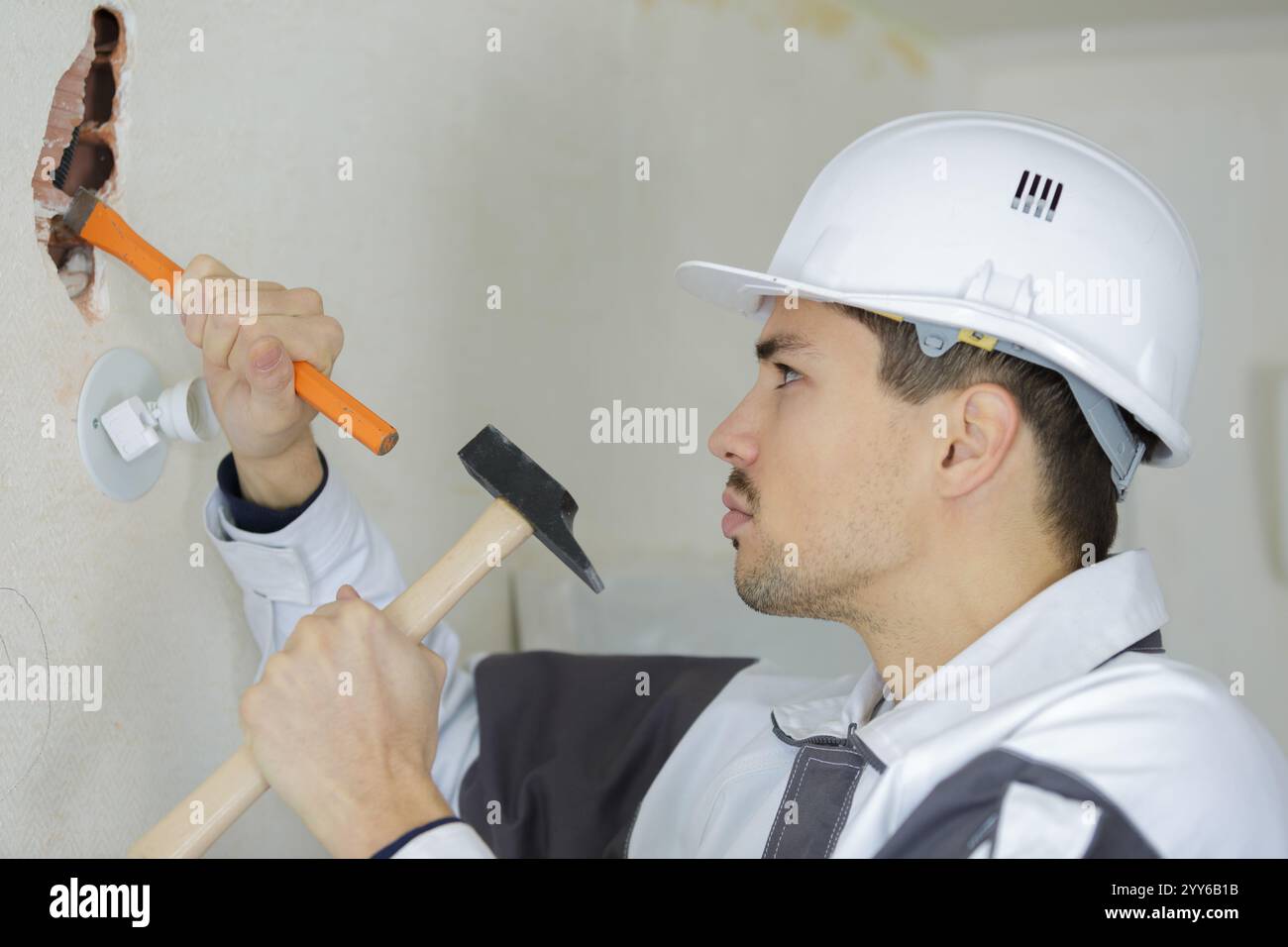 the photo depicts a man with a chisel and hammer Stock Photo - Alamy