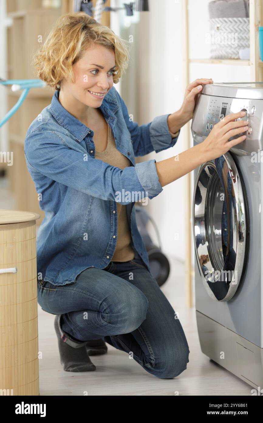 happy woman turning a dial knob on a modern washing-machine Stock Photo ...