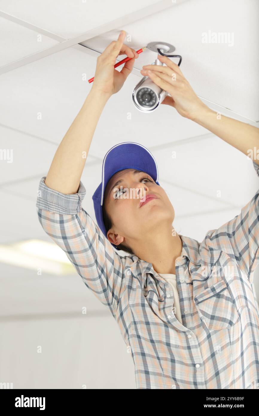 pretty female installing cctv camera Stock Photo - Alamy