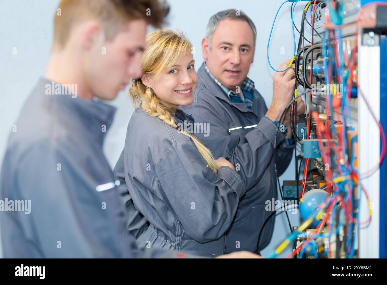 industrial technical female apprentice and trainer looking at young man ...