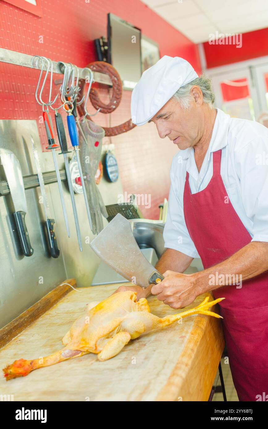 Butcher holding machete to chop up chicken Stock Photo - Alamy