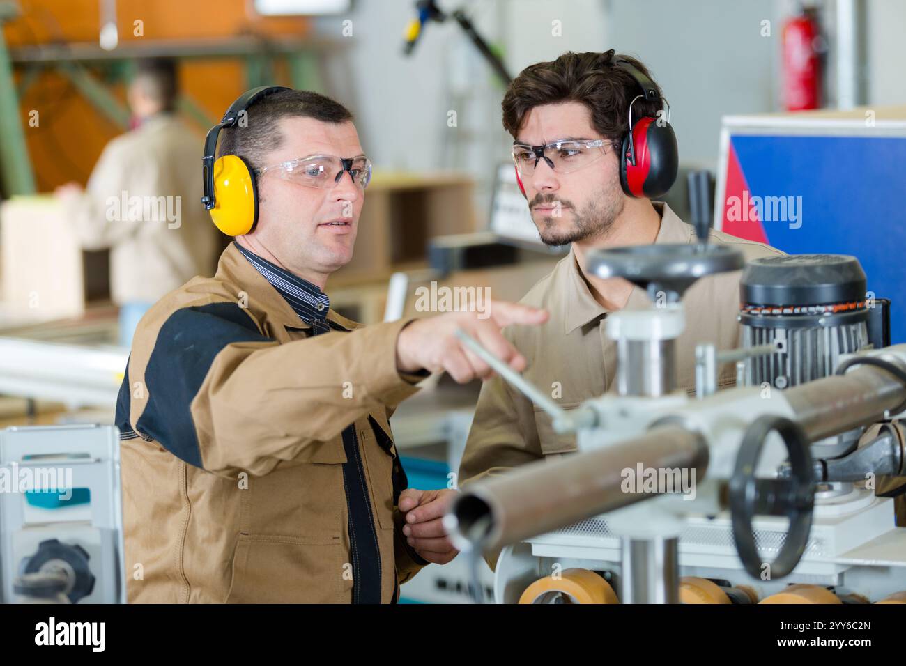 metal craftsman teaching know-how to young man Stock Photo - Alamy