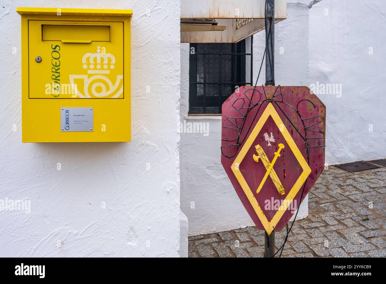 Bright yellow mailbox and historic Guardia Civil sign in Andalusian ...