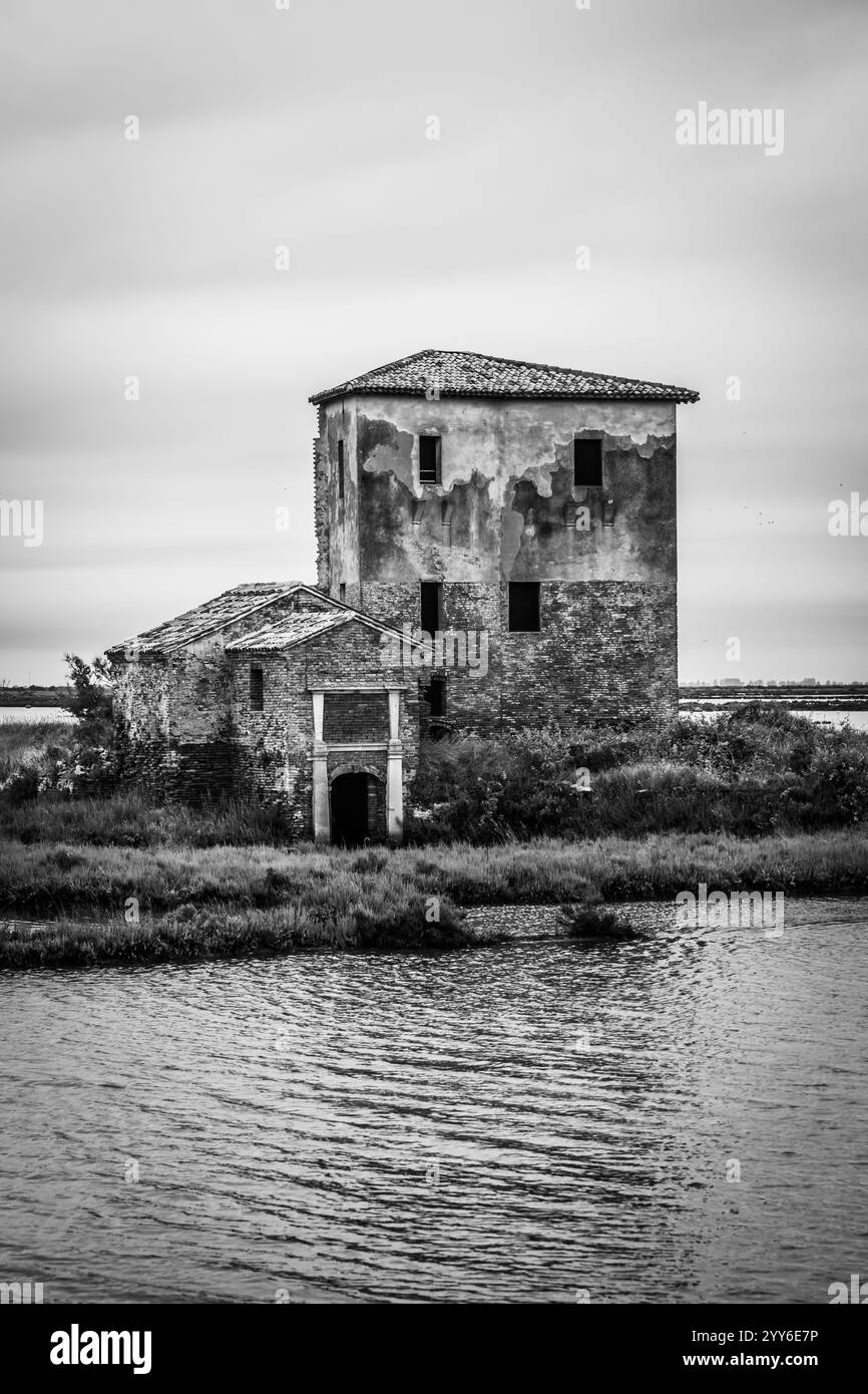 Abandoned building in front of a lagoon. Creepy construction exterior ...