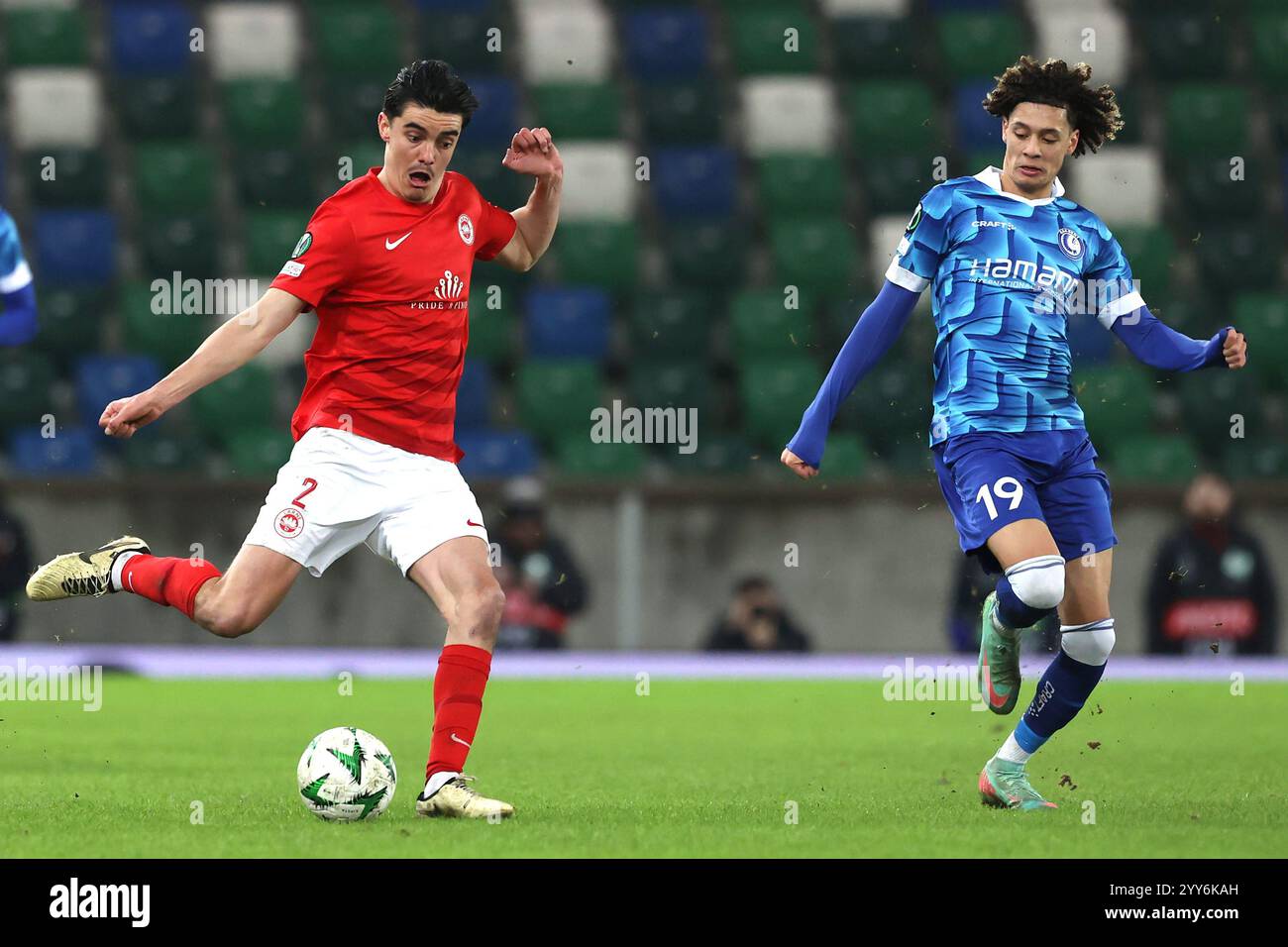 Larne's Shaun Want (left) and Gent's Franck Surdez battle for the ball ...