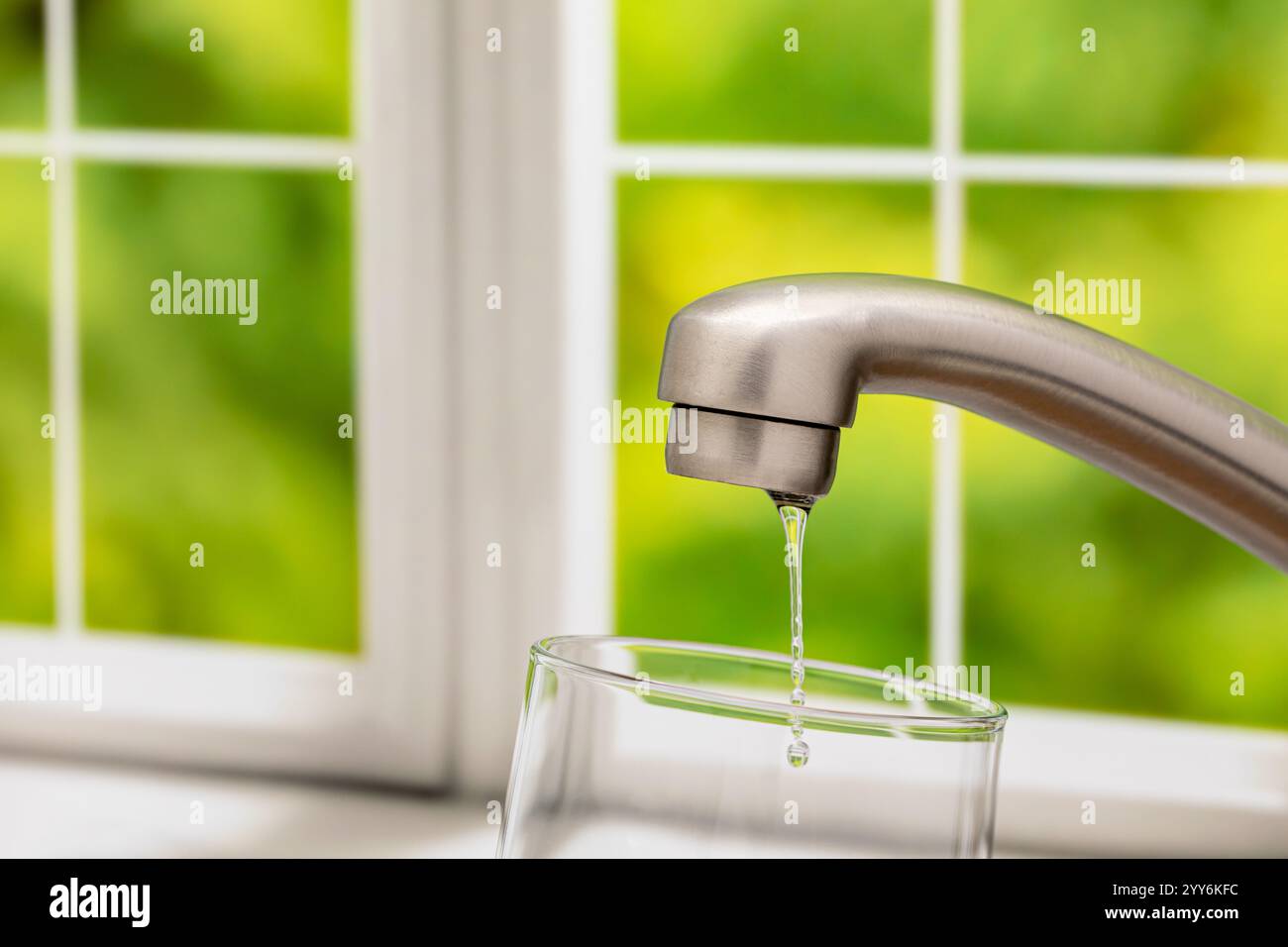 Water dripping from kitchen faucet. Water conservation, shortage and ...