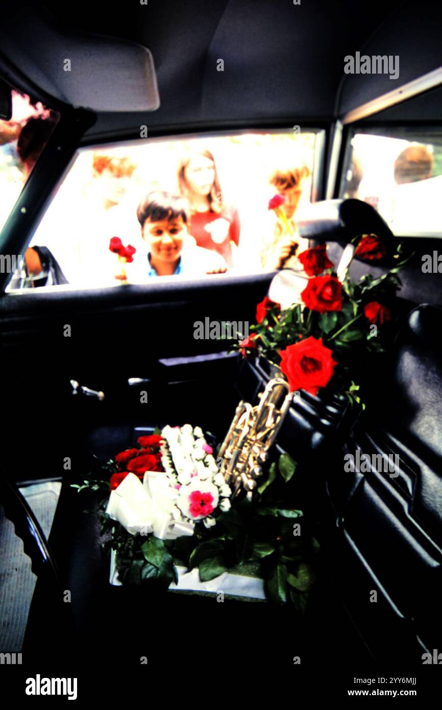 A boy looks through the front windor of the hearse for Louis Armstrong ...