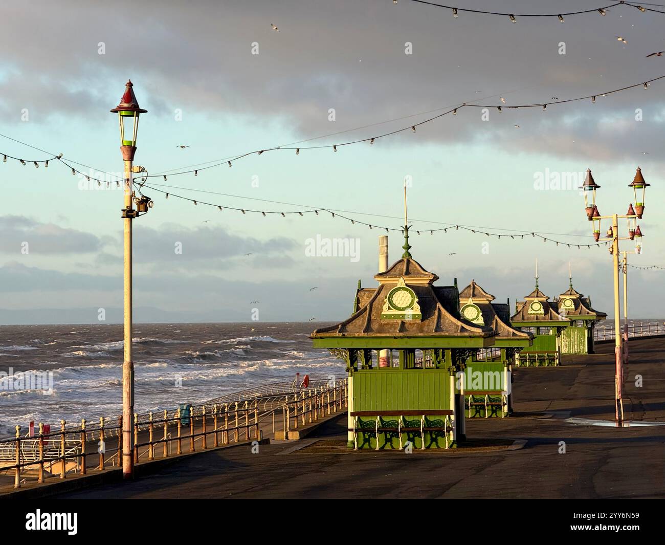 Traditional green wooden shelters on North promenade at Blackpool on a ...
