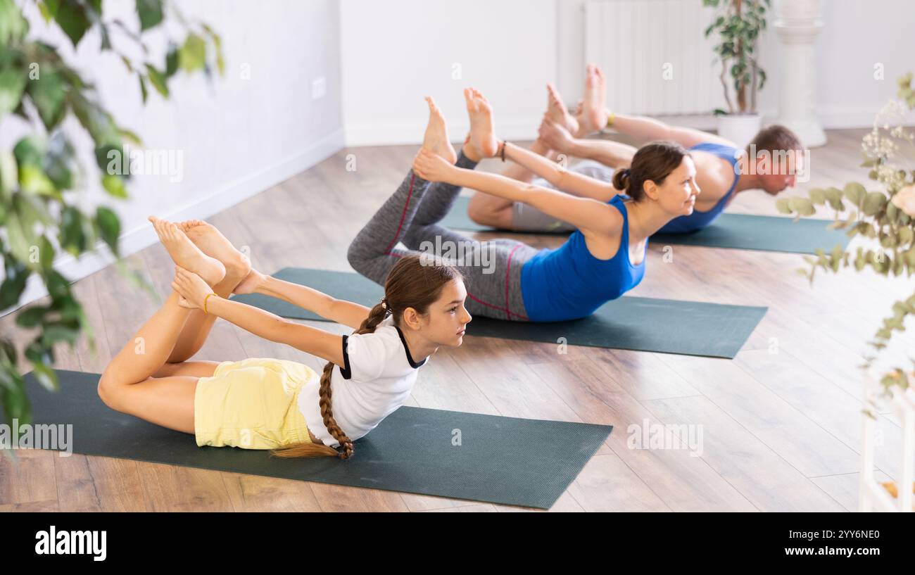 Teen girl doing back bending asana Dhanurasana known as Bow Pose during ...