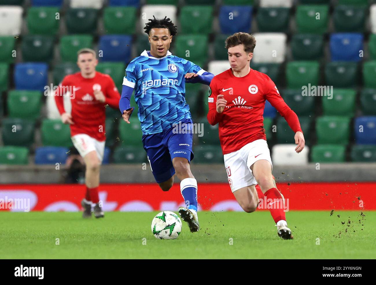 Gent's Momodou Sonko and Larne's Matthew Lusty (right) battle for the ...