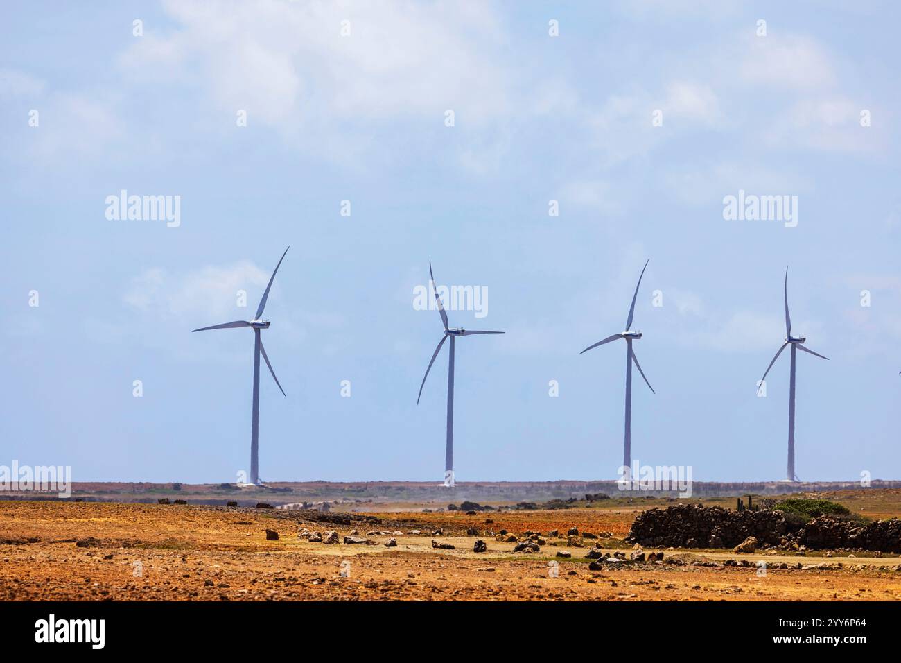Wind turbines on Aruba island in desert landscape with clear blue sky ...