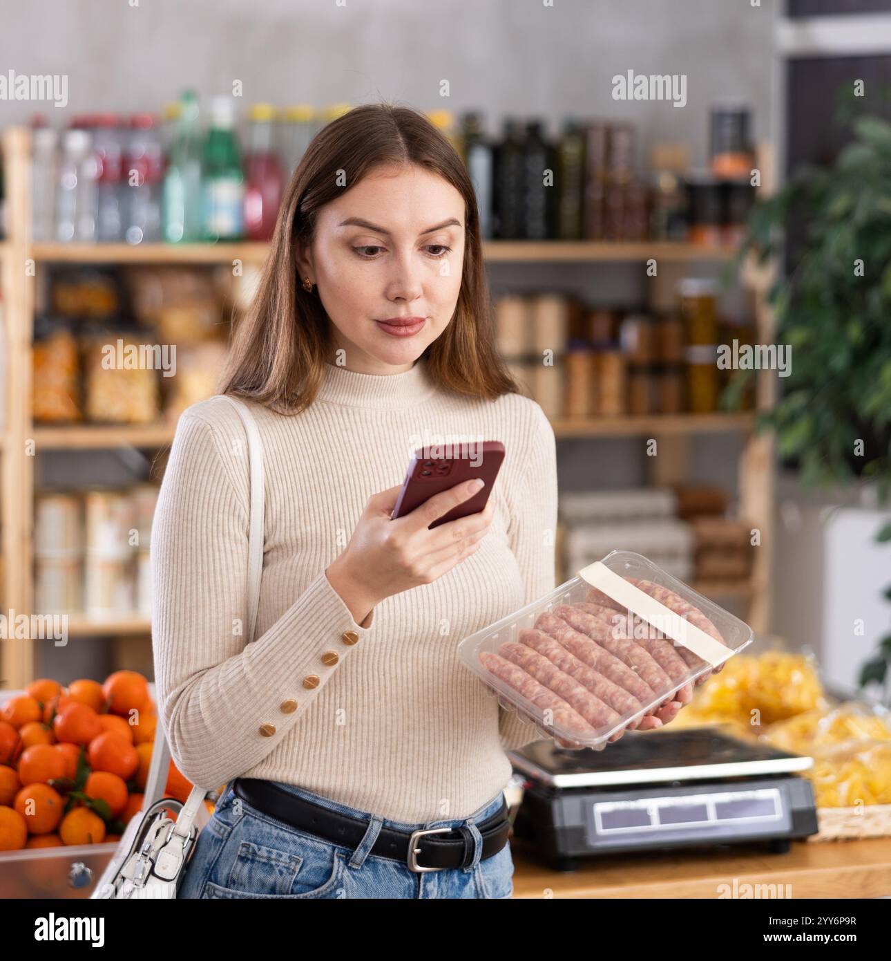 Girl scan QR-code on raw pork sausages in store Stock Photo - Alamy
