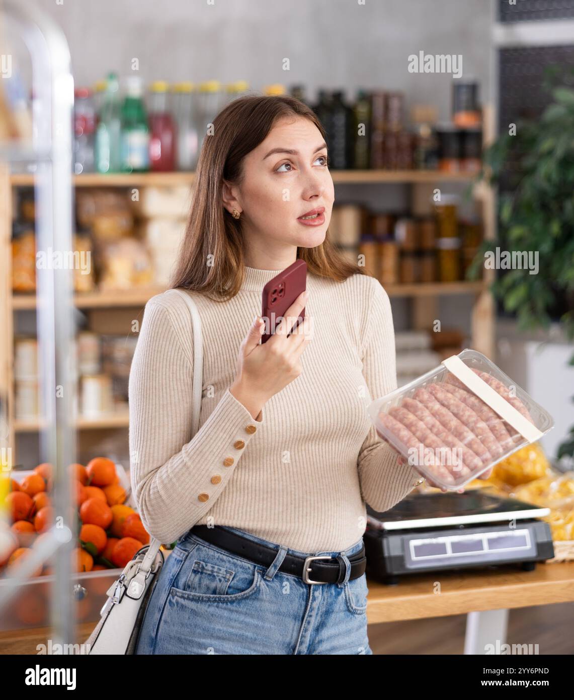Girl scan QR-code on raw pork sausages in store Stock Photo - Alamy