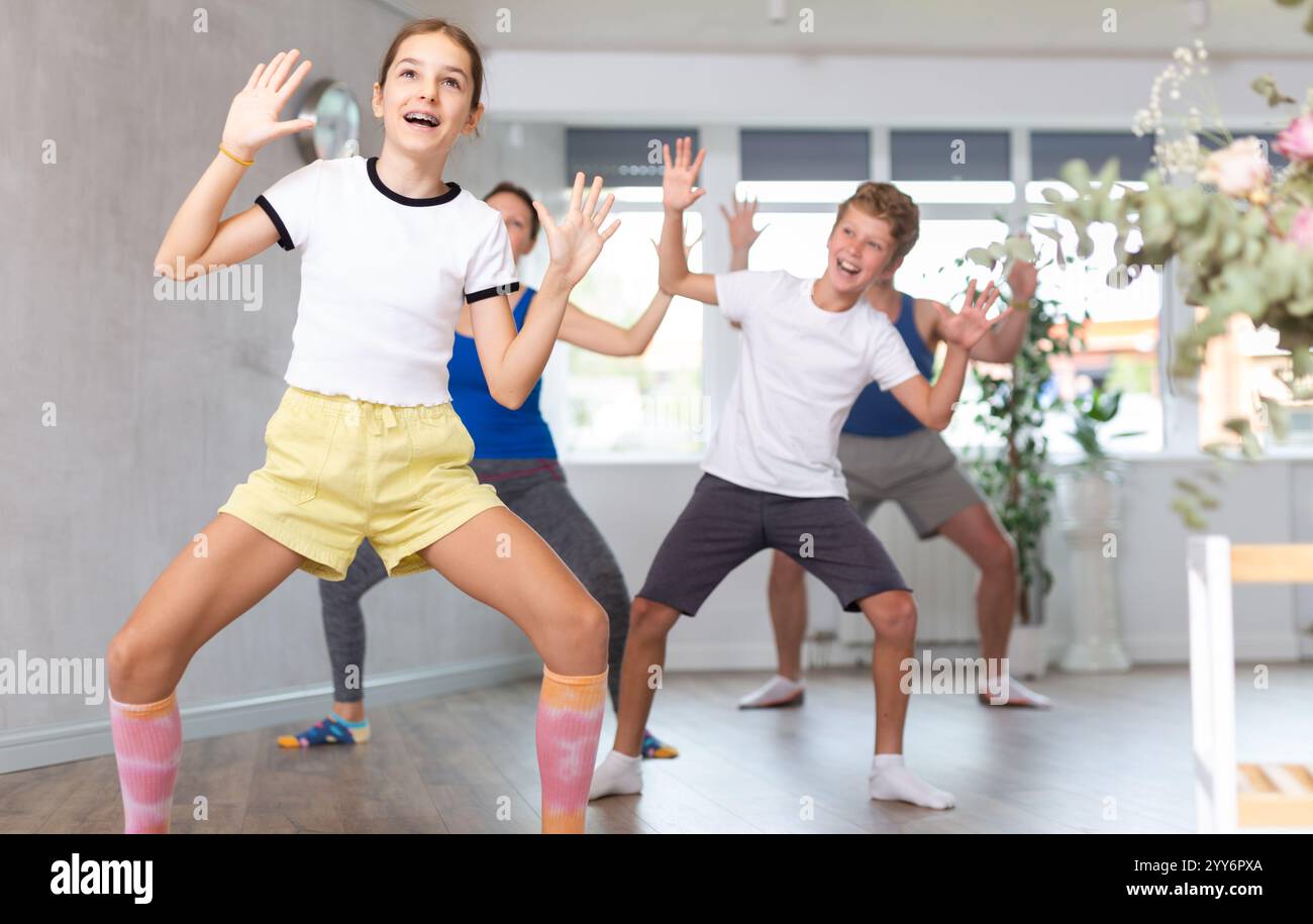 Happy preteen girl practicing dance movements with her family Stock ...