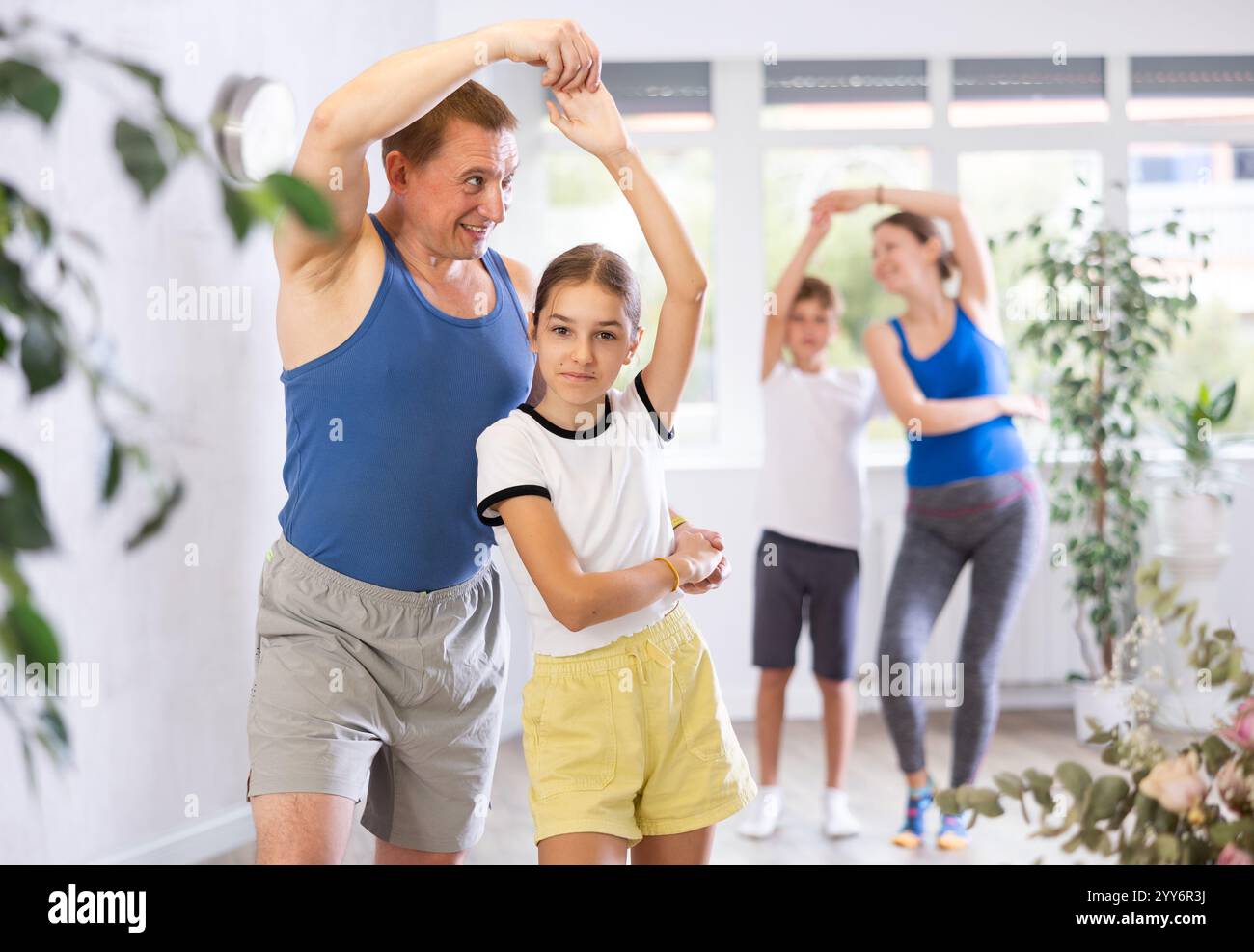 Happy father and daughter practicing dance in pairs together with other ...