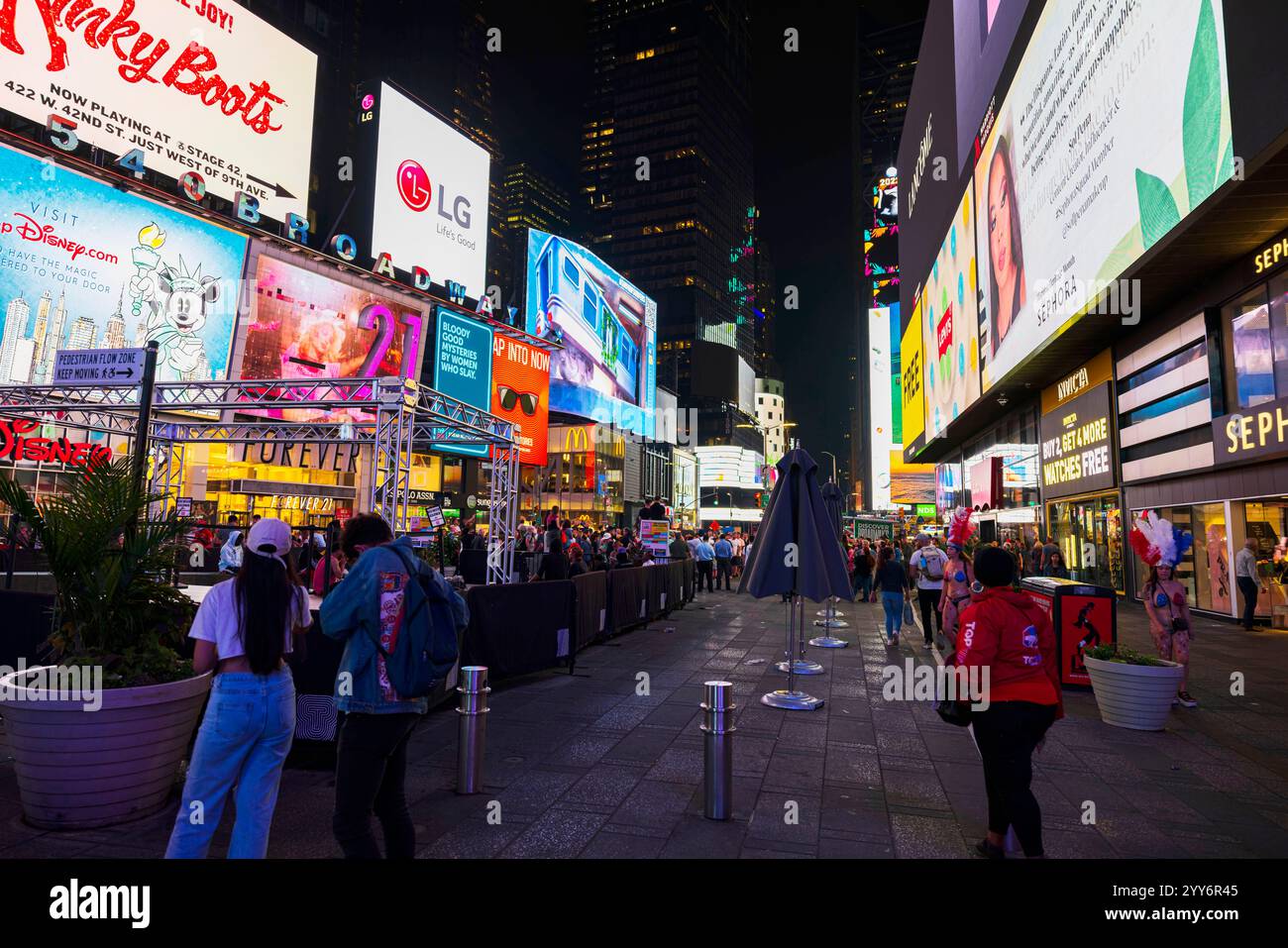Street-level view of bustling Times Square at night with illuminated ...