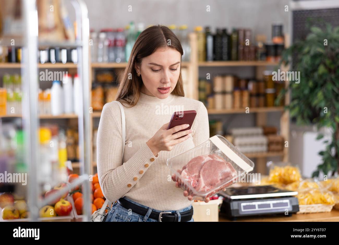 Girl scan QR-code on raw pork package in store Stock Photo - Alamy
