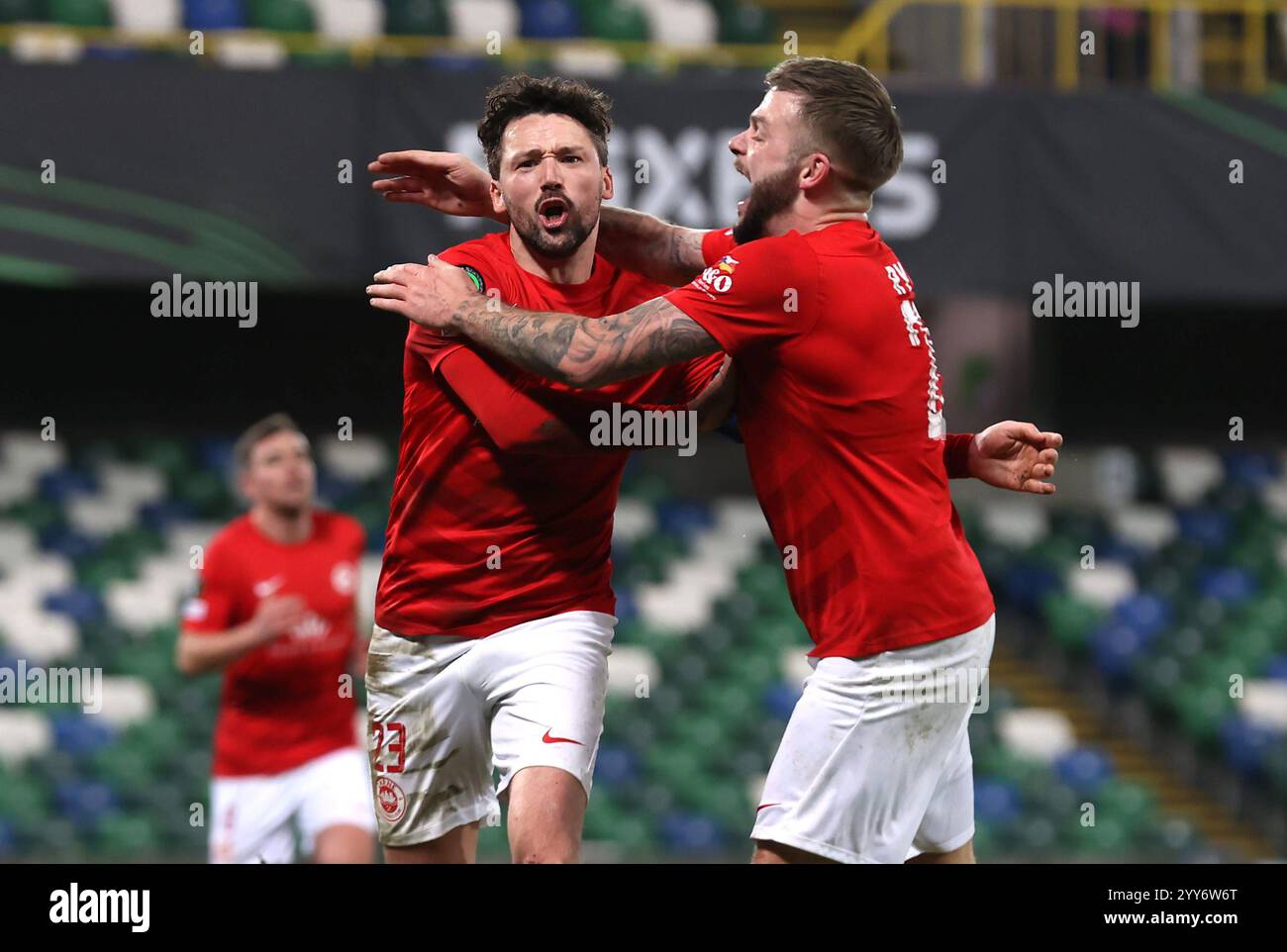 Larne's Tomas Cosgrove (left) celebrates scoring their side's first ...
