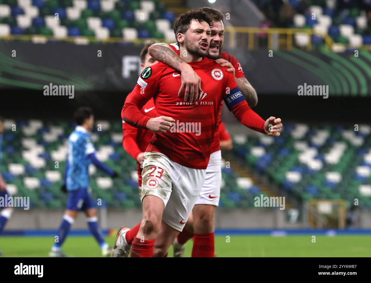 Larne's Tomas Cosgrove (left) celebrates scoring their side's first ...