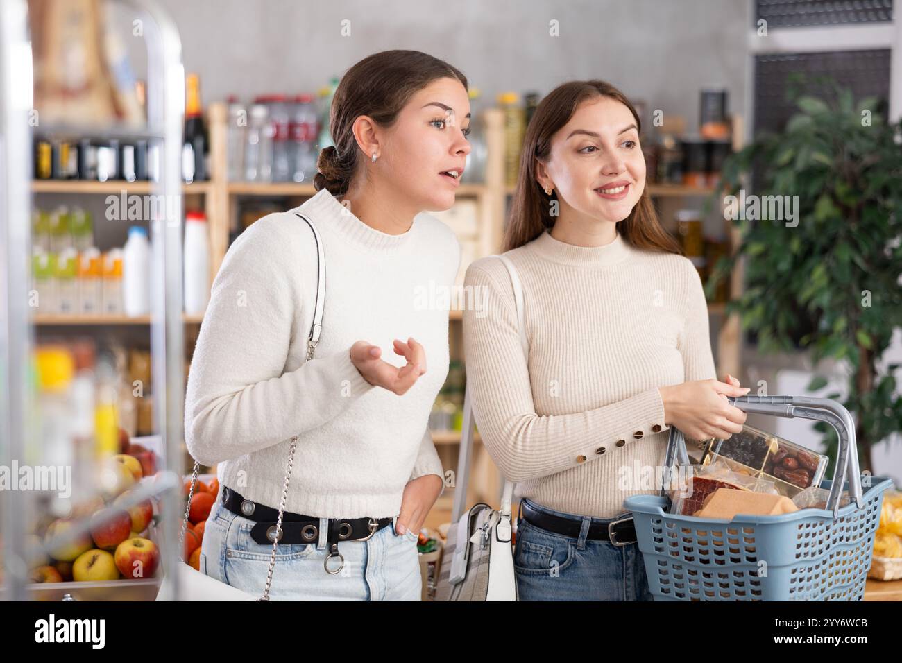 Two friends choose and buy groceries together in the grocery department ...