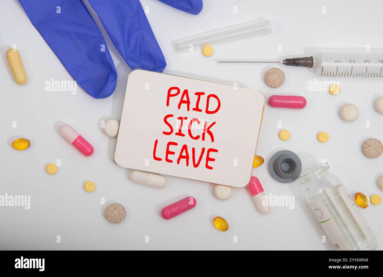 PAID SICK LEAVE text on blue pieces of paper on yellow background ...