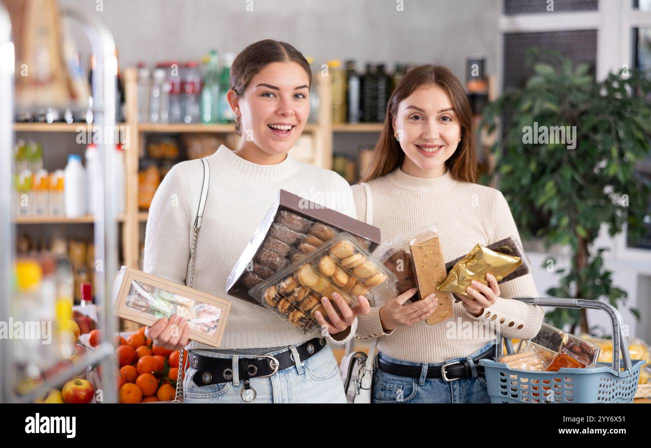 Two girls in store while shopping, choose sweets and chat sweetly Stock ...