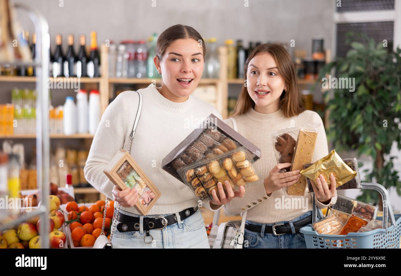 Two girls in store while shopping, choose sweets and chat sweetly Stock ...