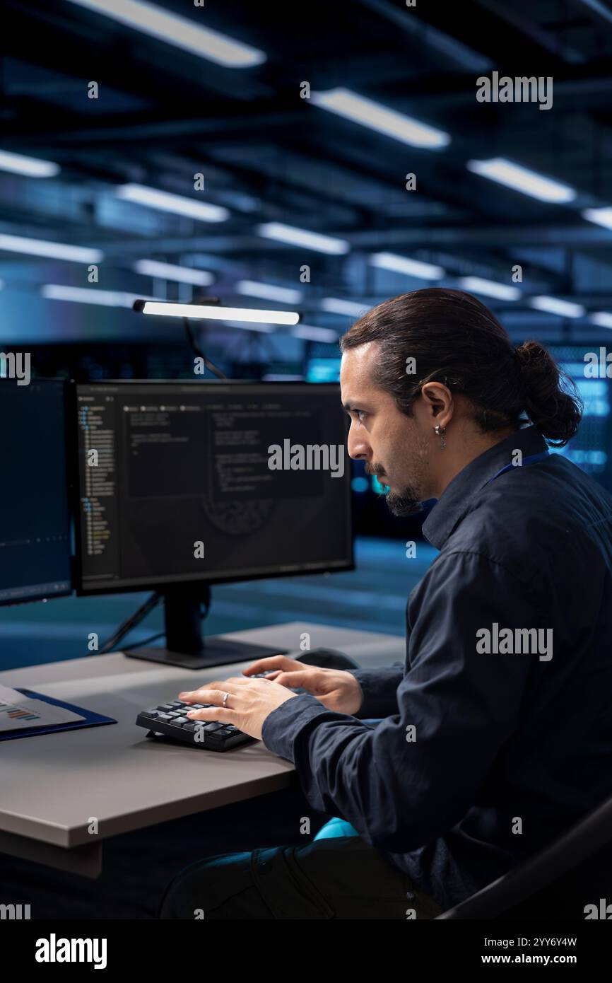 Admin typing on desktop PC in server farm establishment, ensuring data remains shielded from ...