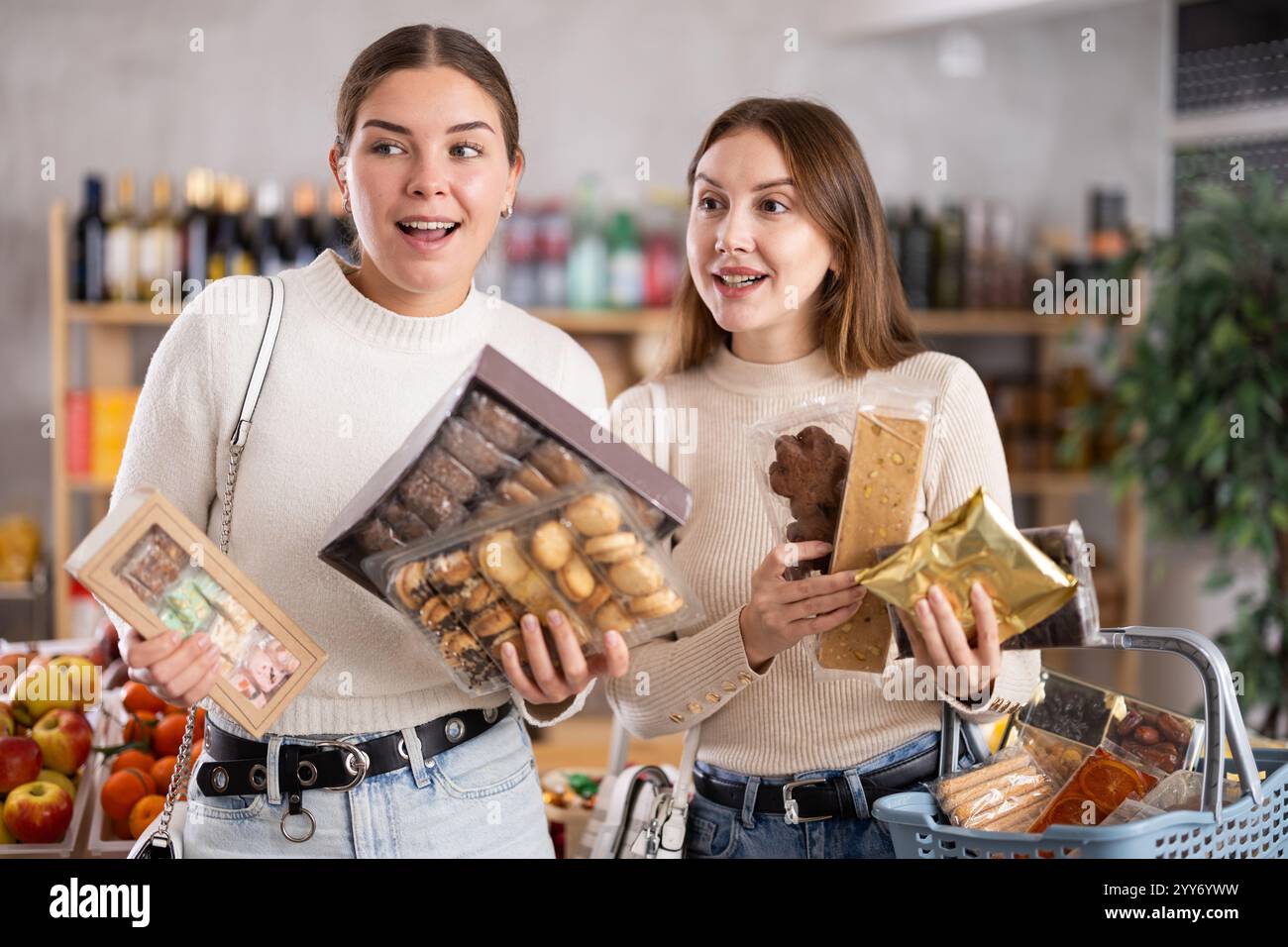 Two friends buy various sweets together - cookies and nougat in grocery ...